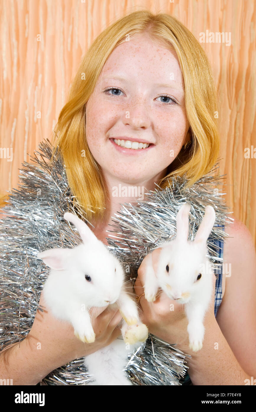 Teen girl with two pet rabbits sitting in home Stock Photo - Alamy