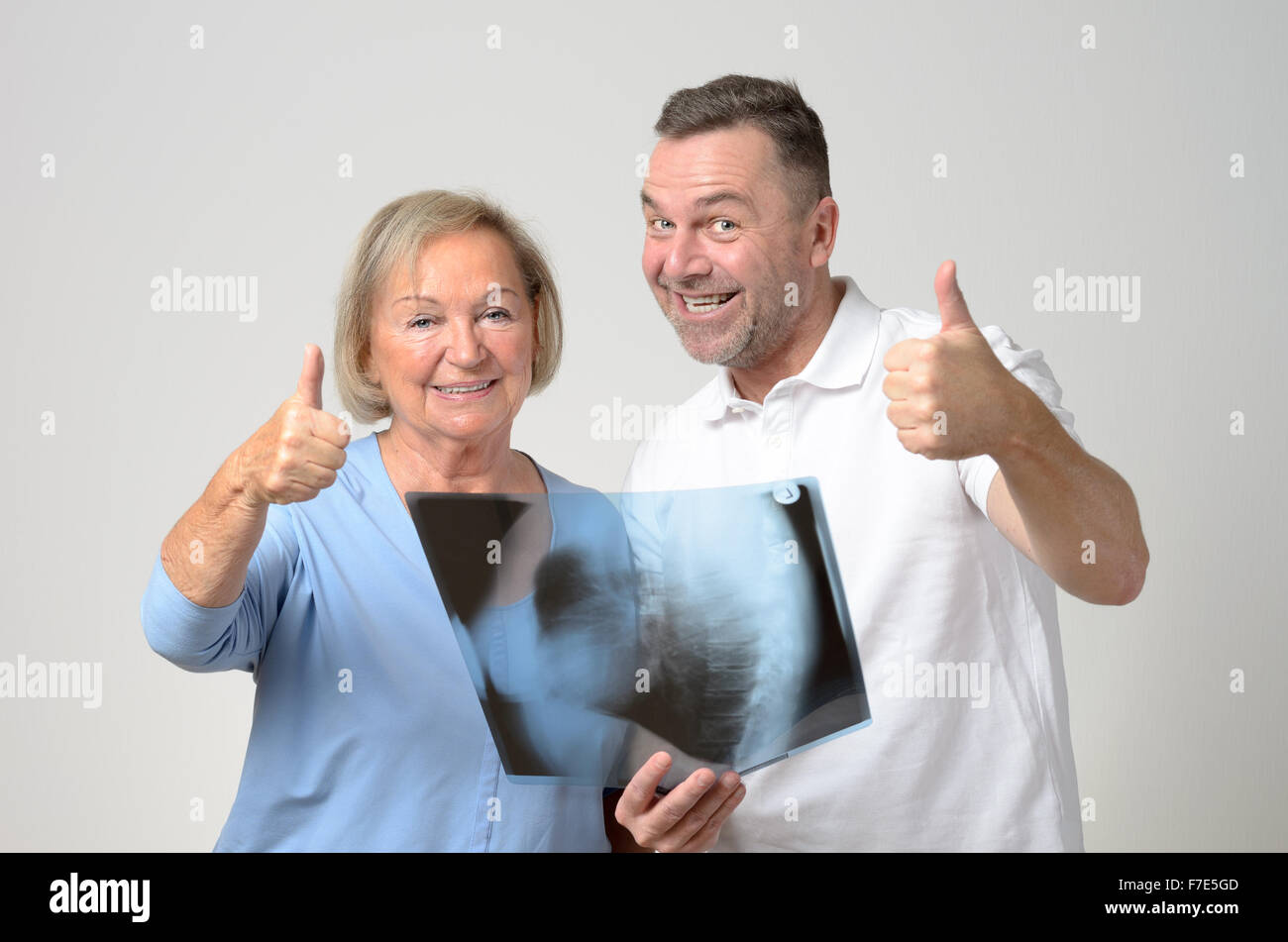 Doctor discussing an x-ray with an elderly female patient as they stand ...
