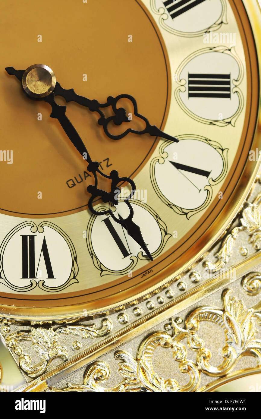 an old gold clock with roman numbers on white background Stock Photo ...