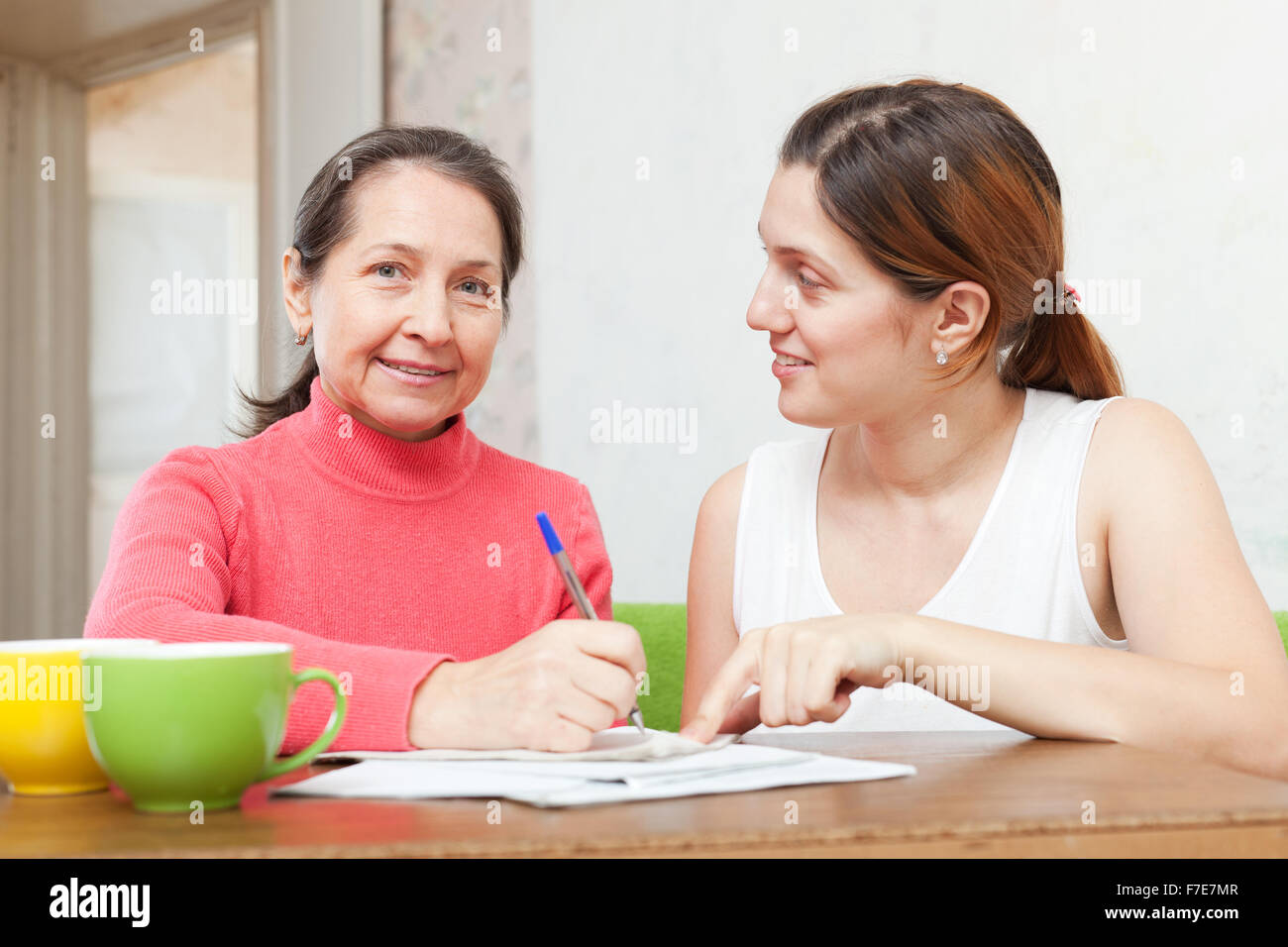Adult daughter with mother fills in the questionnaire at home Stock ...