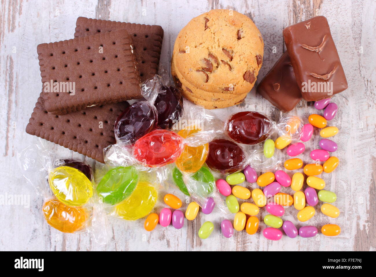 Heap of colorful candies and cookies on old white wooden background ...