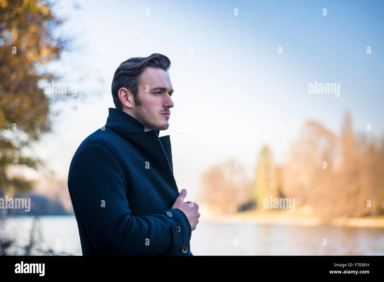 Handsome young man outdoor in winter fashion, wearing black coat and ...