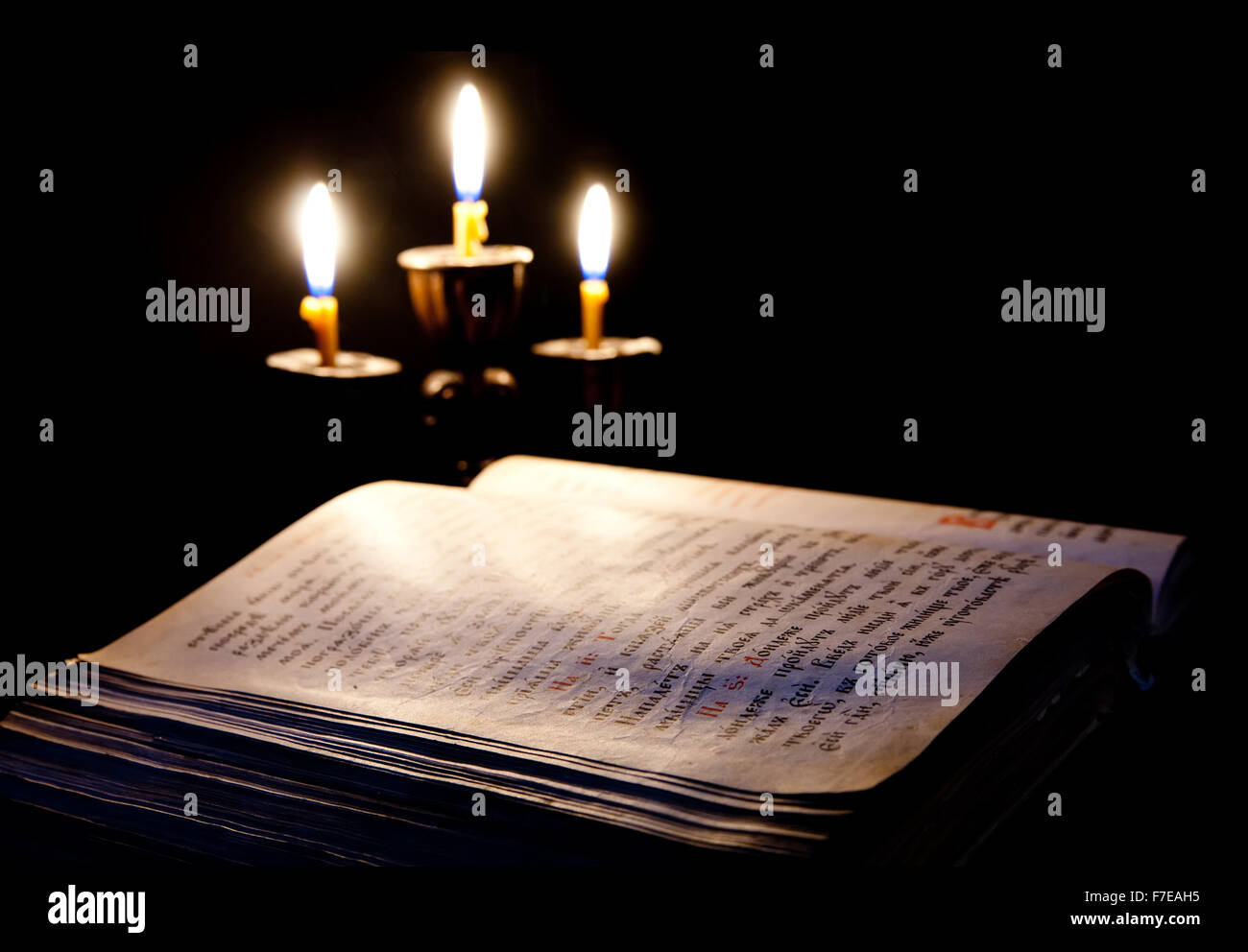 old Psalter and candles in candelabrum against black Stock Photo - Alamy