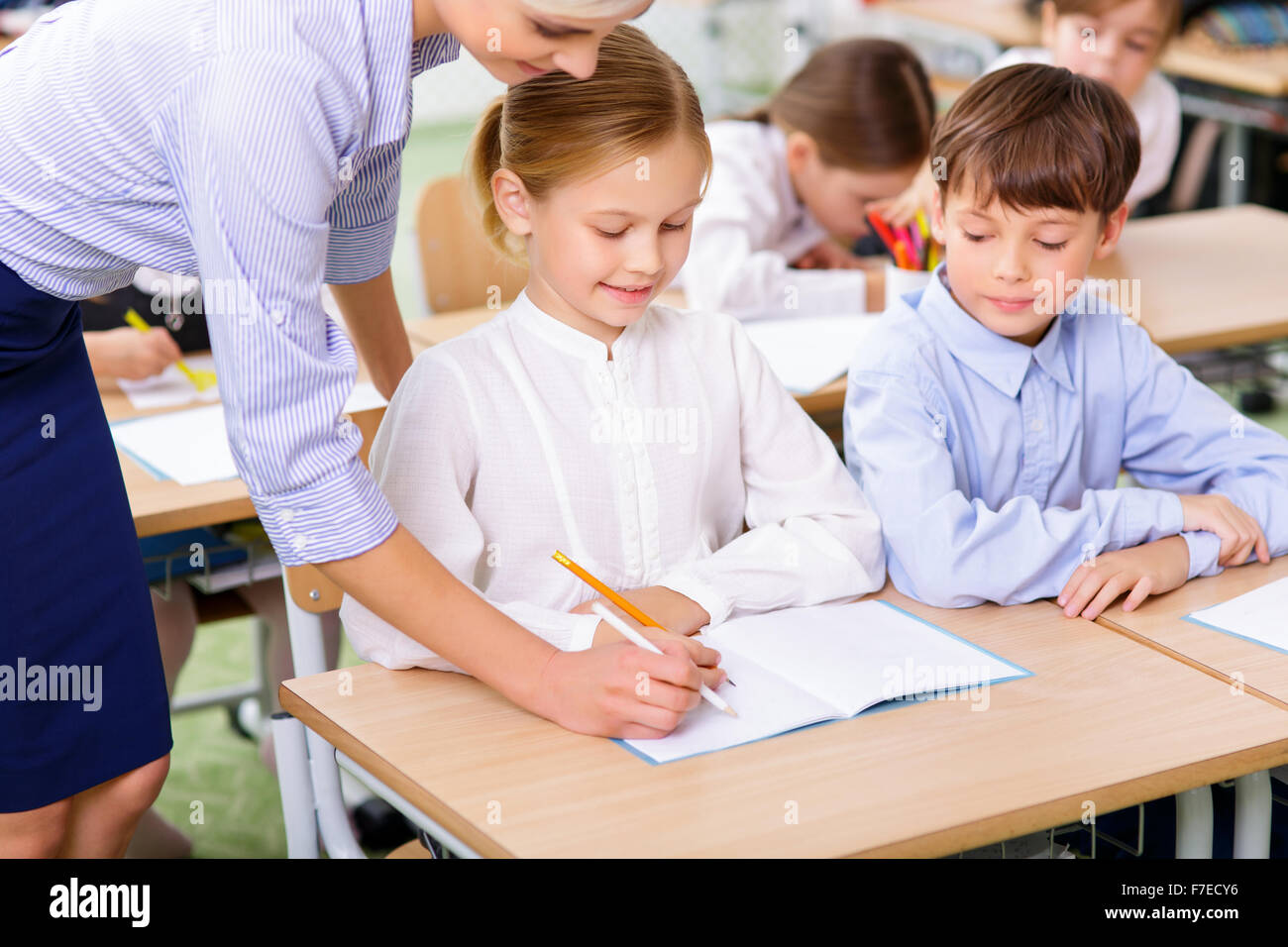 Teacher and her pupil are writing together Stock Photo - Alamy