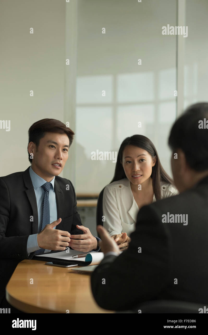 Singapore, Three business people talking at desk Stock Photo - Alamy
