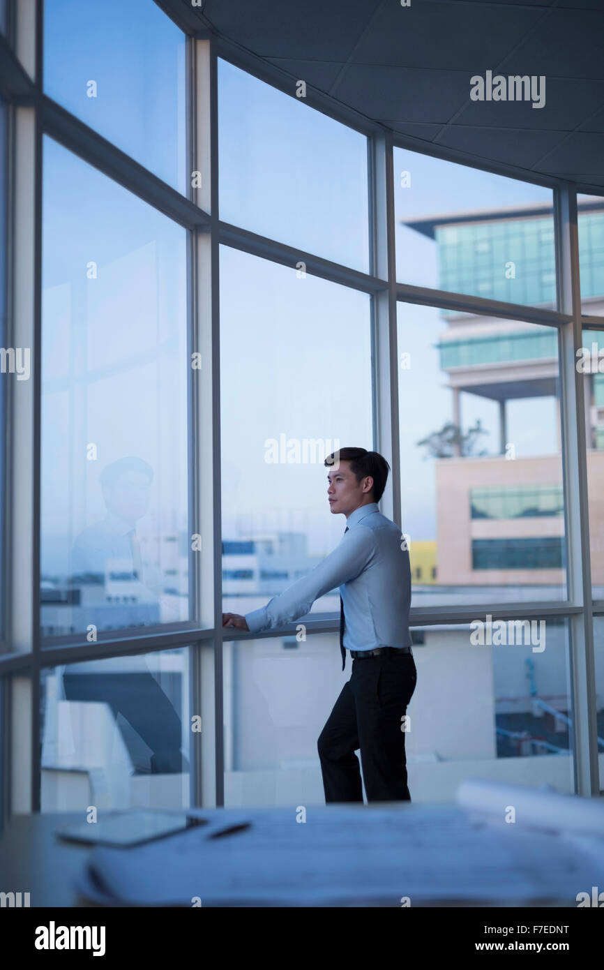 Singapore, Architect leaning against window Stock Photo - Alamy