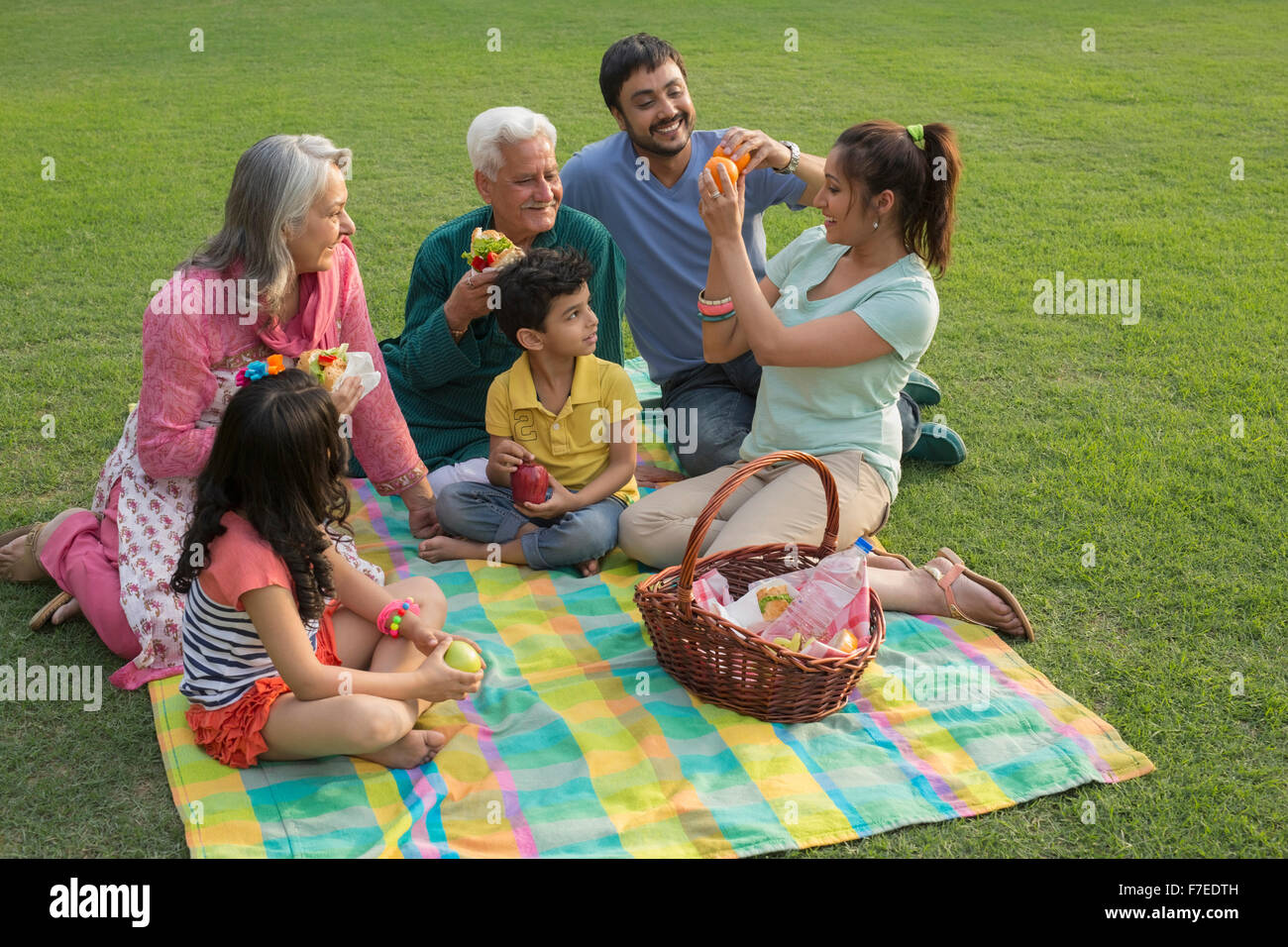 Mother handing out food at family picnic with children (4-5 Stock Photo ...