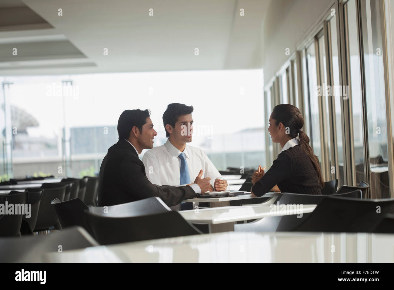 India, Three colleagues having discussion in large empty room Stock ...