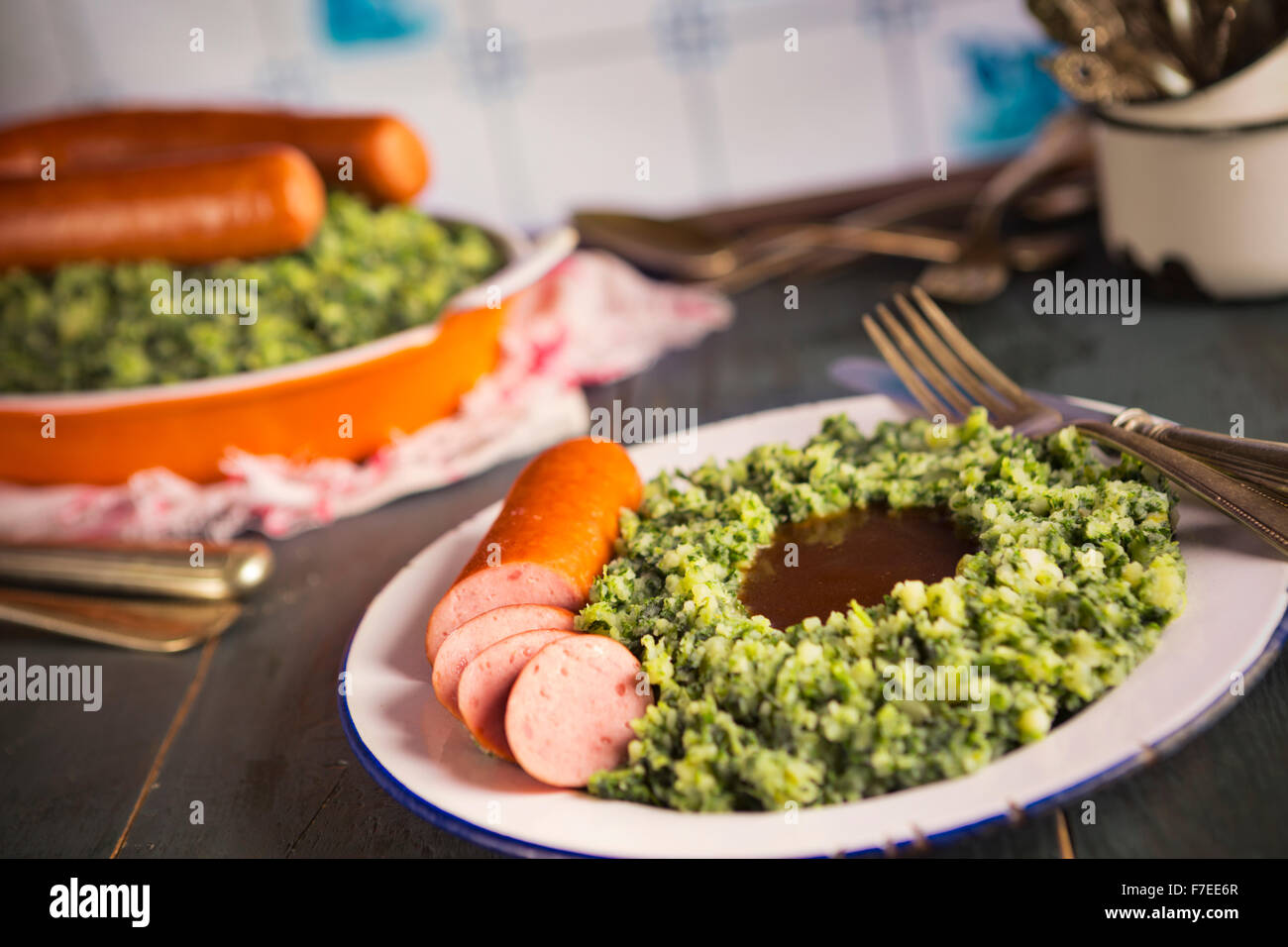 A rustic kitchen with a plate with 'Boerenkool met worst' or kale with ...