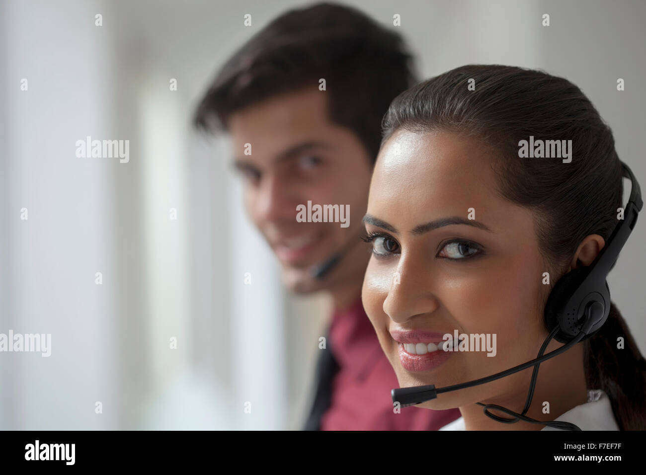 India, Two telemarketers smiling to camera Stock Photo - Alamy
