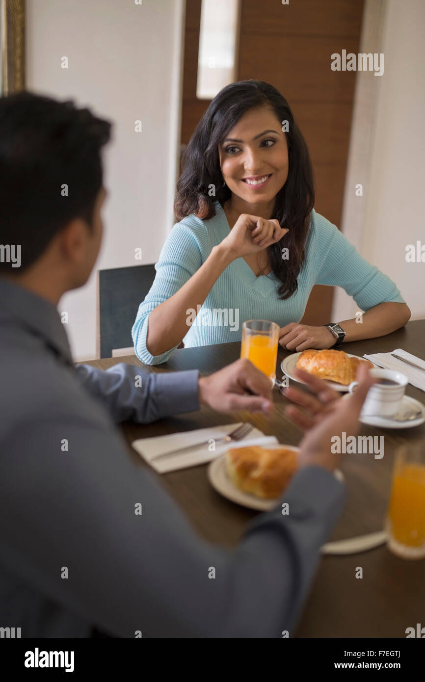 India, Woman smiling at man at breakfast table Stock Photo - Alamy