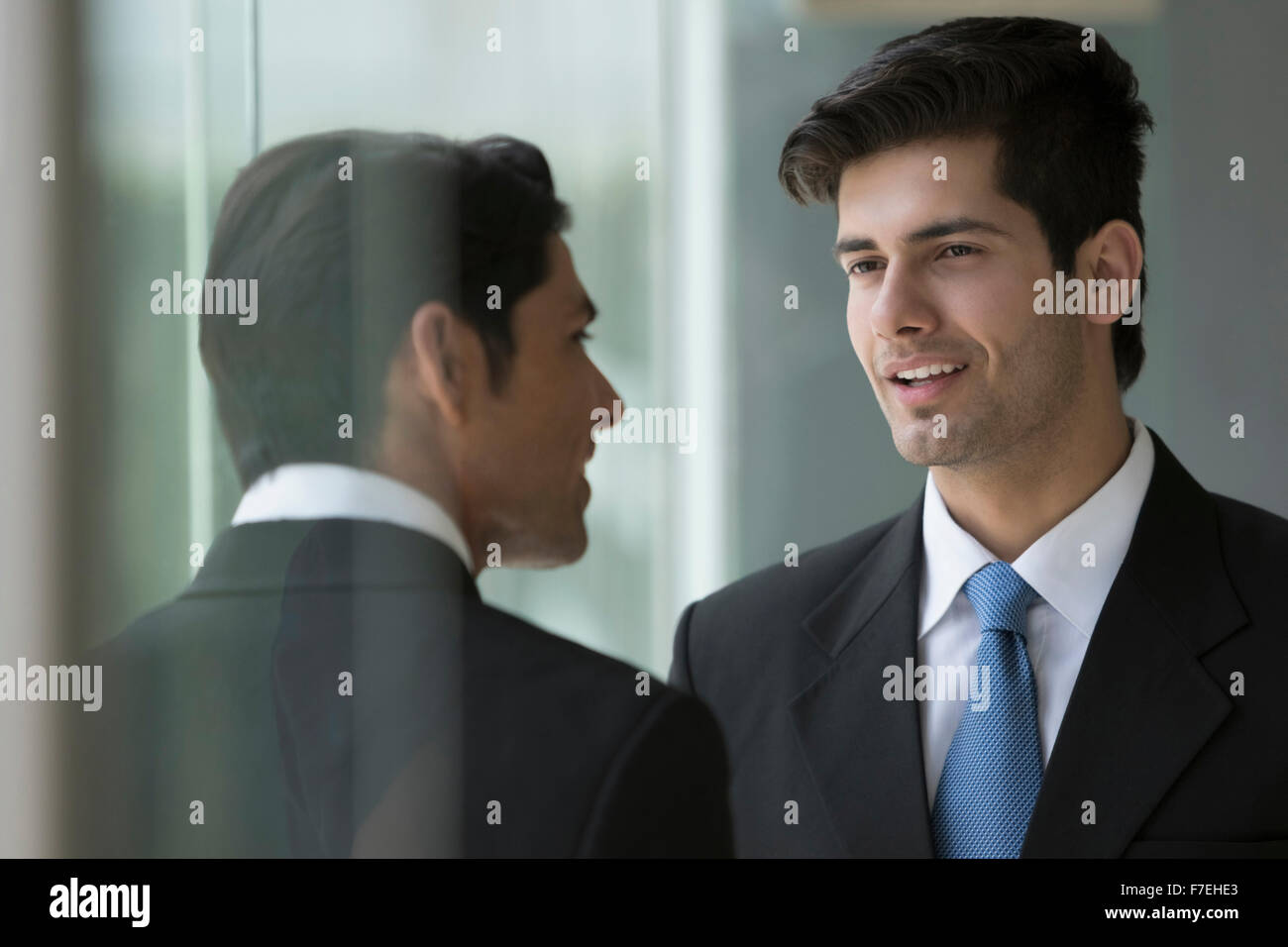 Two male colleagues talking to each other Stock Photo - Alamy