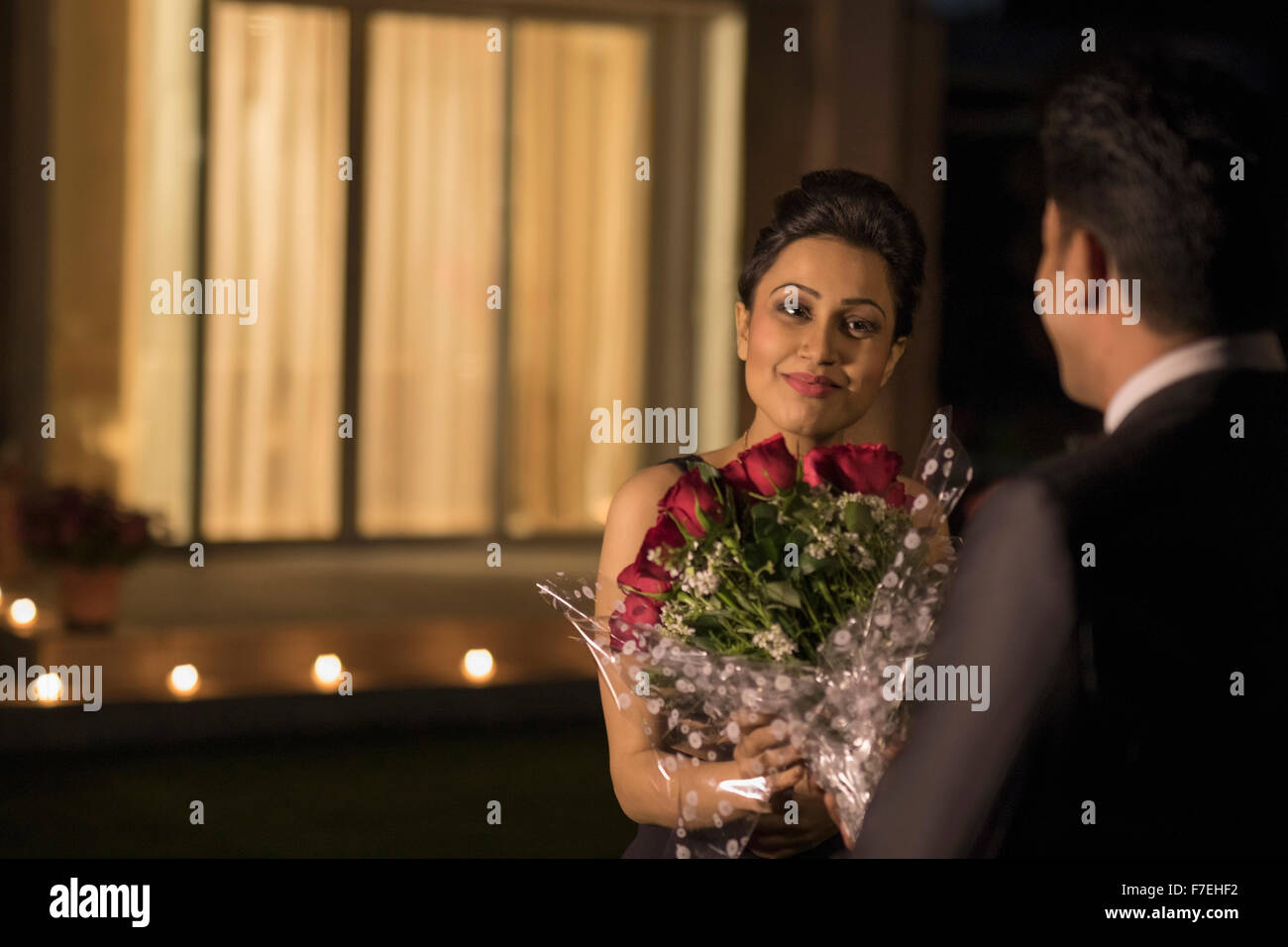 Woman taking roses from man in evening wear Stock Photo - Alamy
