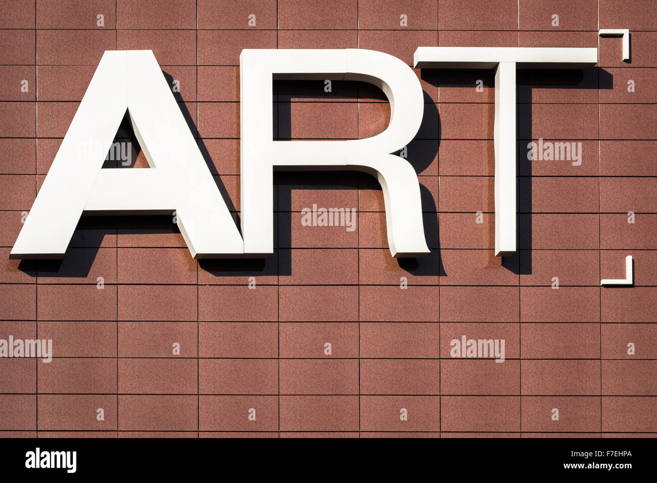Single white Art sign on a red stone background Stock Photo - Alamy