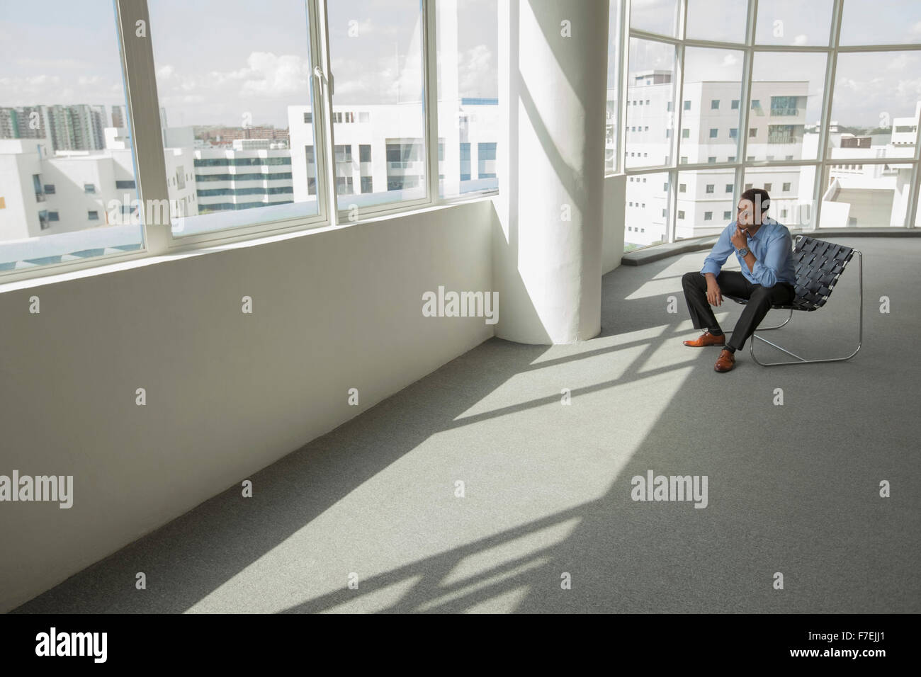 Singapore, Businessman sitting in chair in empty office Stock Photo - Alamy