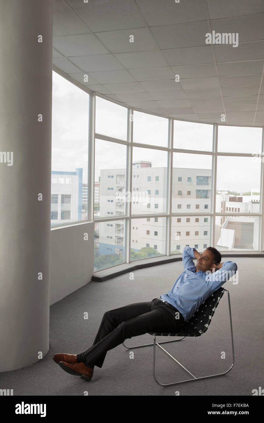 Singapore, Businessman sitting in chair in empty office Stock Photo - Alamy