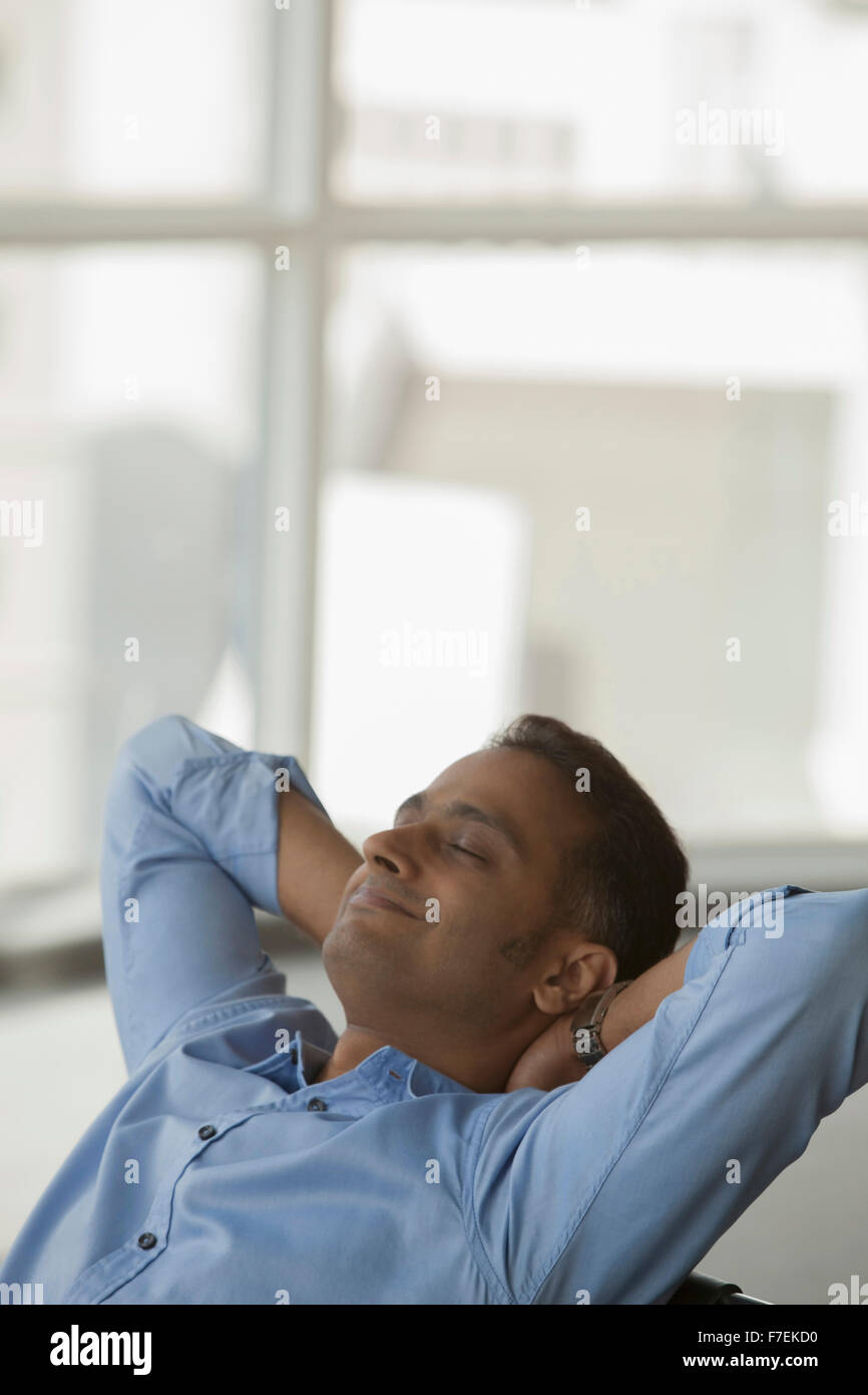 Singapore, Businessman reclining in chair in empty office Stock Photo ...