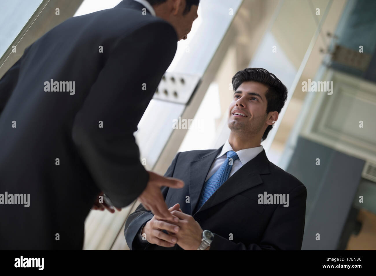 India, Two businessmen in suits talking Stock Photo - Alamy