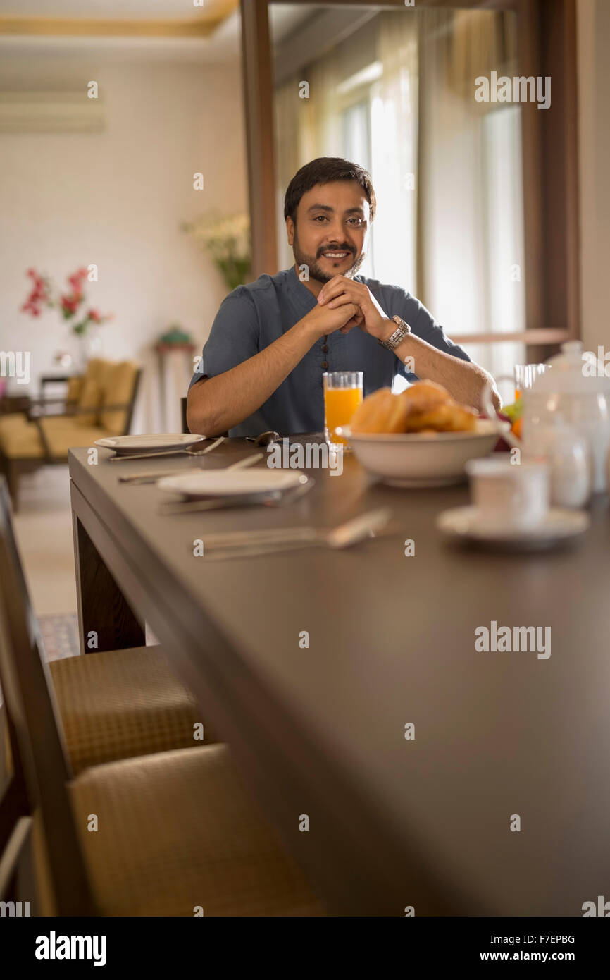 man at breakfast table hands folded under chin Stock Photo - Alamy
