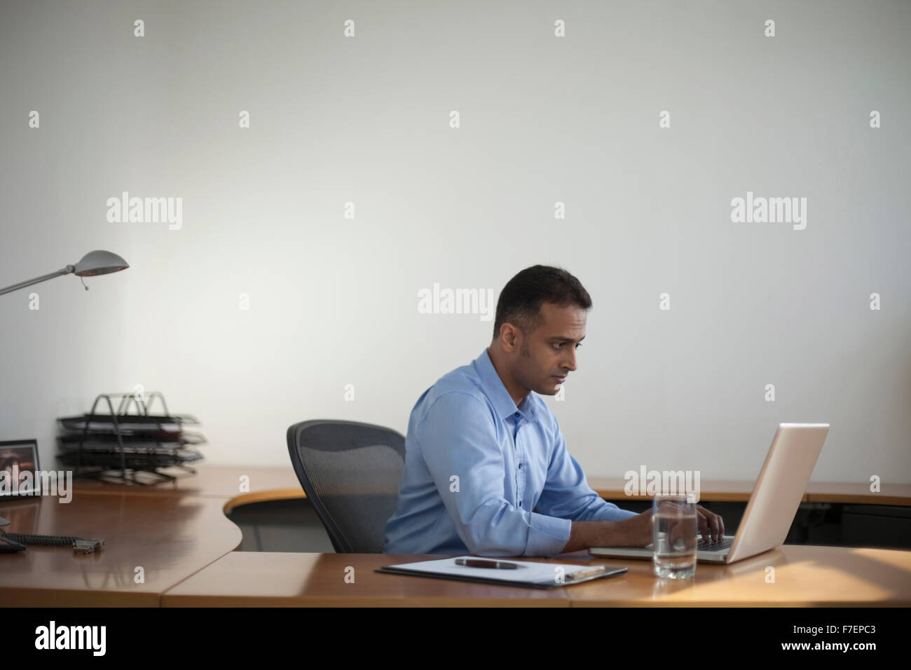 Singapore, Businessman working at laptop in office Stock Photo - Alamy