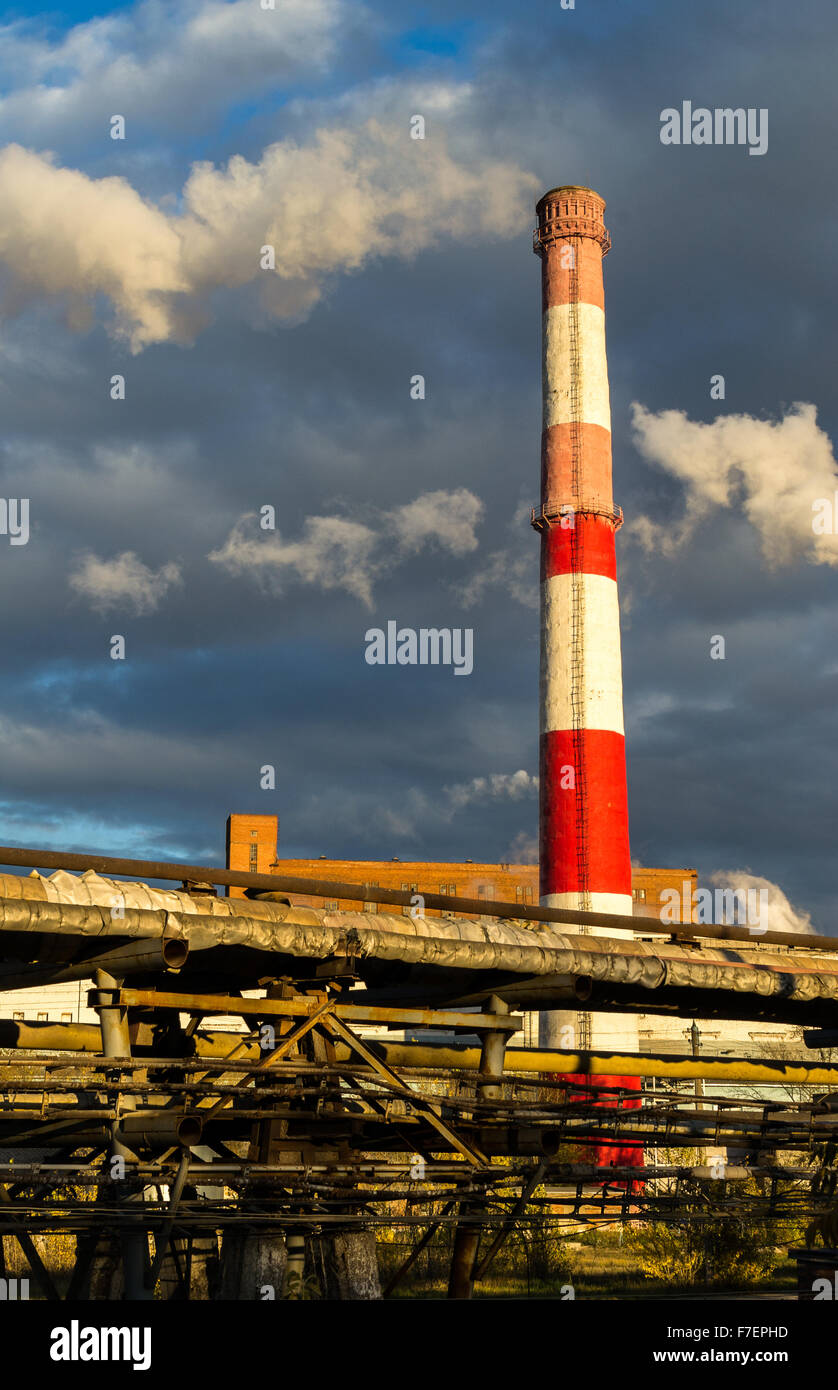 Huge industrial factory chimney in red and white rising high above ...
