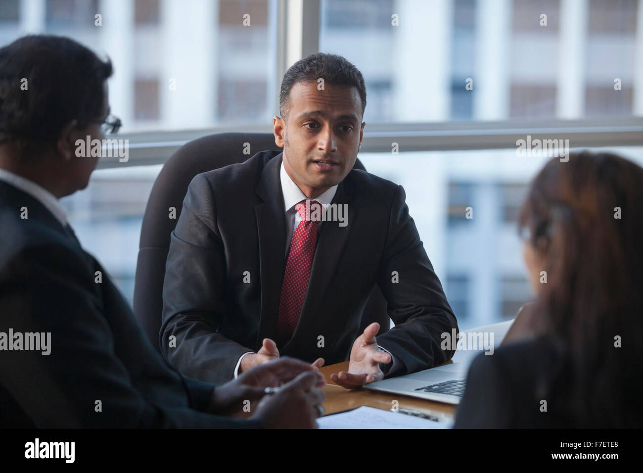 Singapore, Three business people in discussion at conference table ...