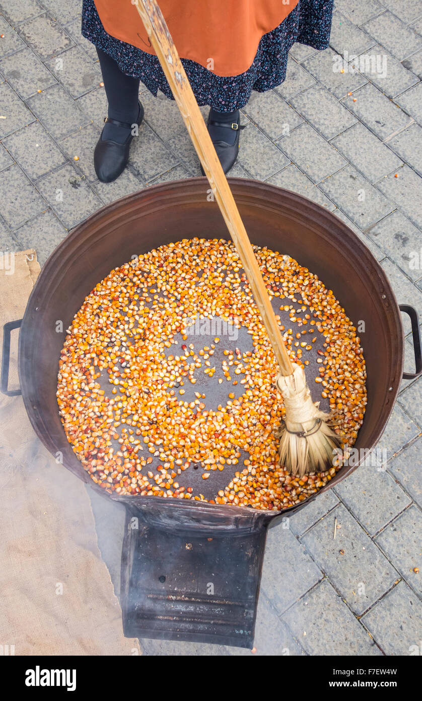 Elderly lady toasting corn the traditional way in La Aldea village ...