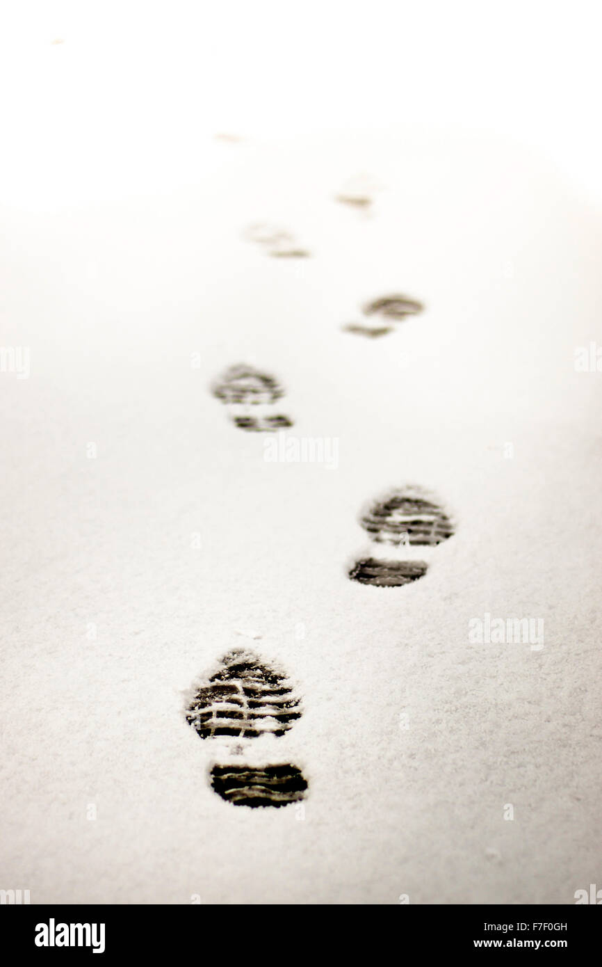 Single path of human foot boot prints walking away into the distant ...