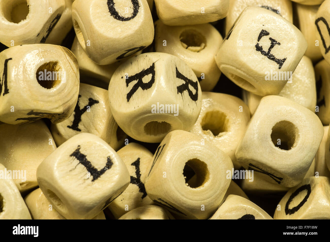 Macro close-up of many hand painted handicraft alphabet wooden beads ...