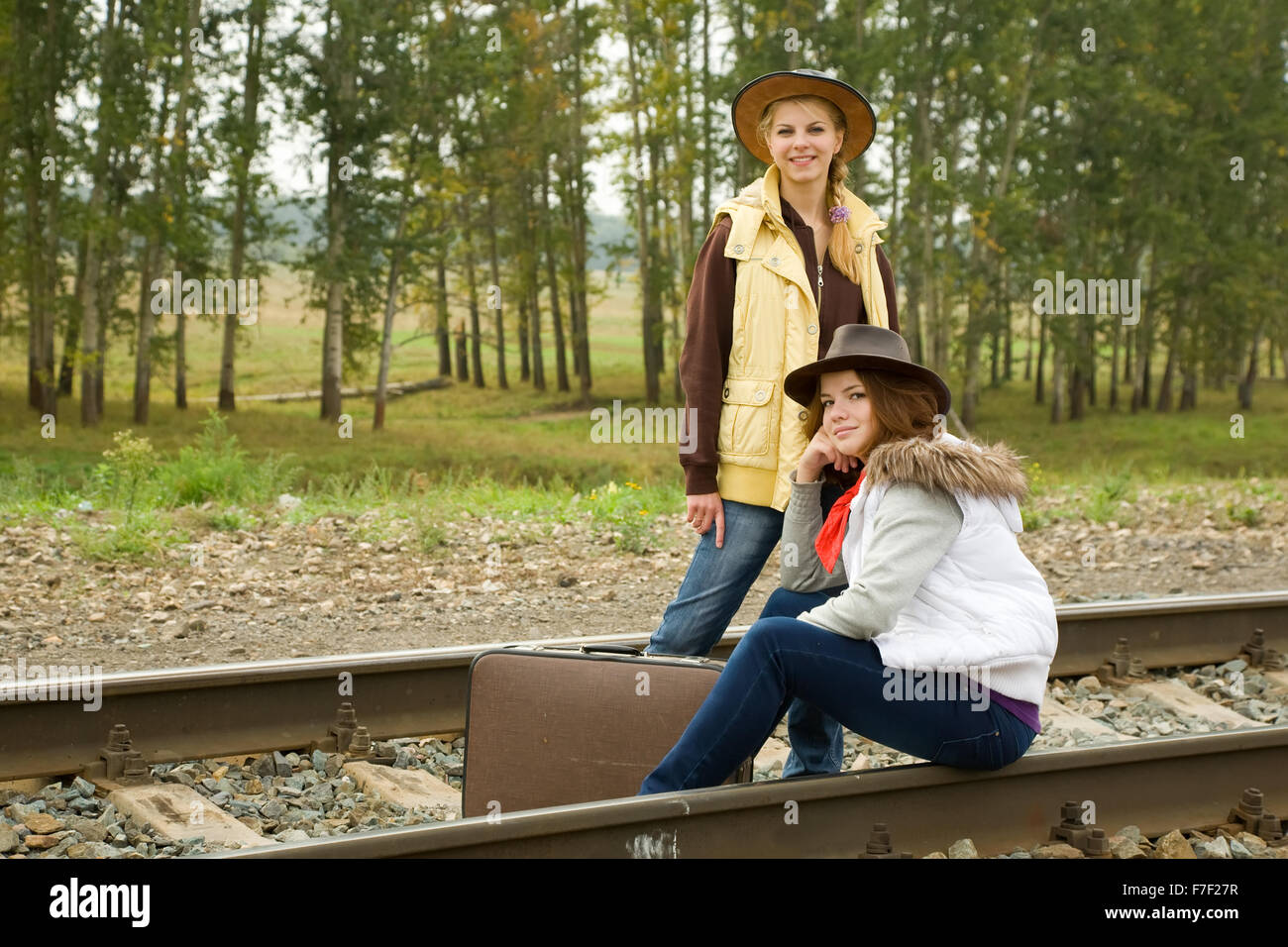girls with suitcase walking along railroad rail Stock Photo - Alamy