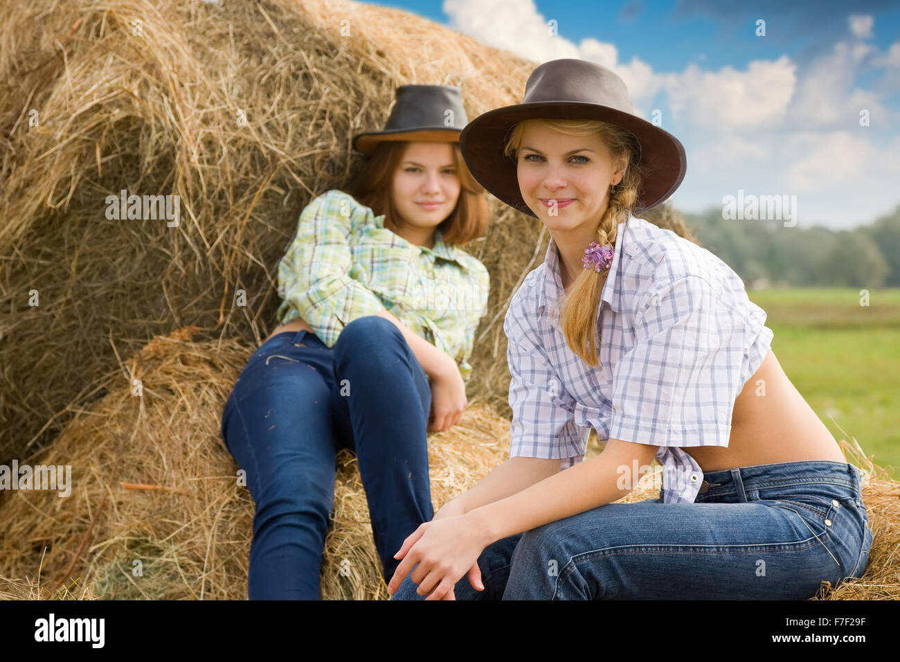 Farm girls on fresh hay at field Stock Photo - Alamy