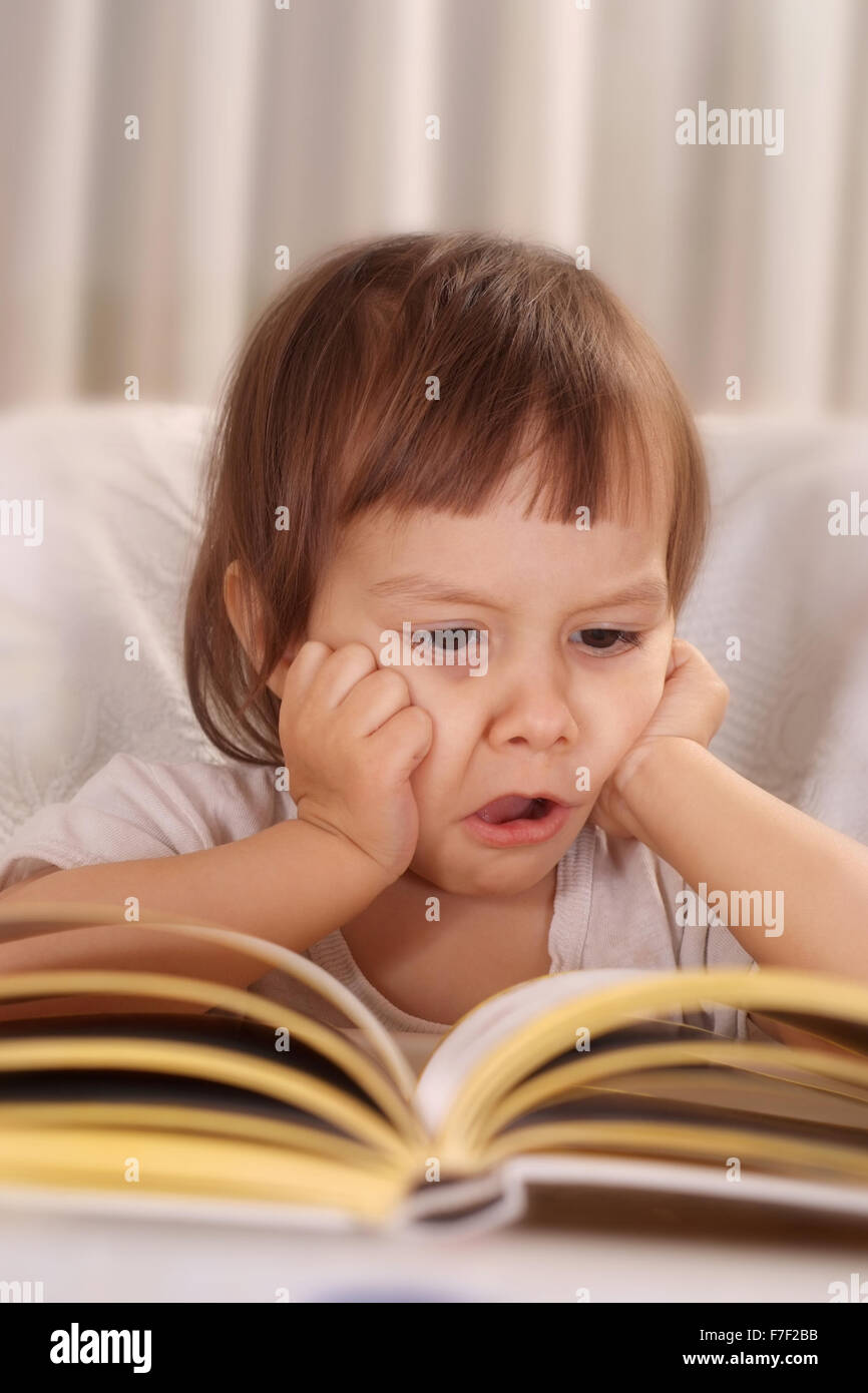 Little girl reading book Stock Photo - Alamy