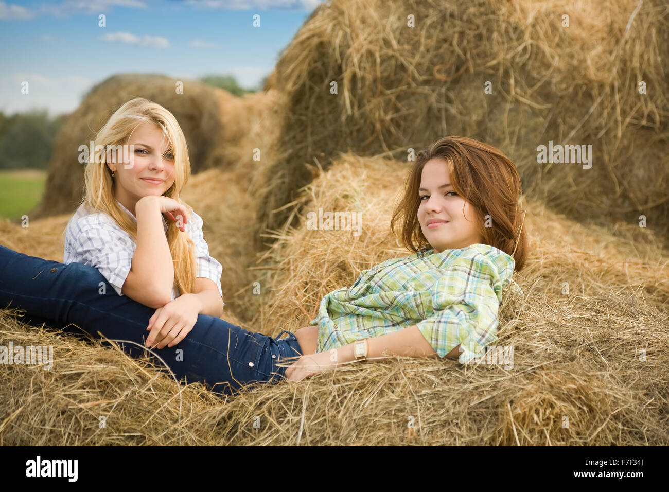 Farm girls on fresh hay at field Stock Photo - Alamy