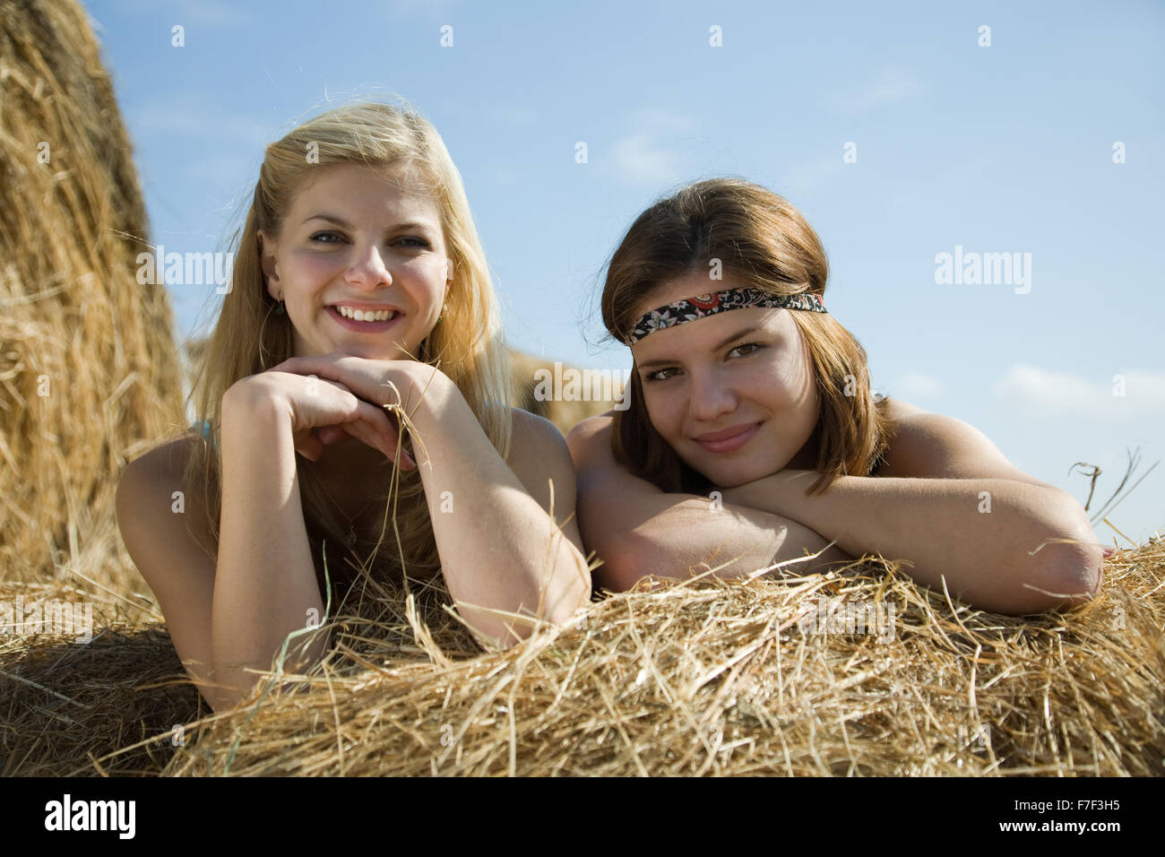 Happy girls on fresh hay at field Stock Photo - Alamy