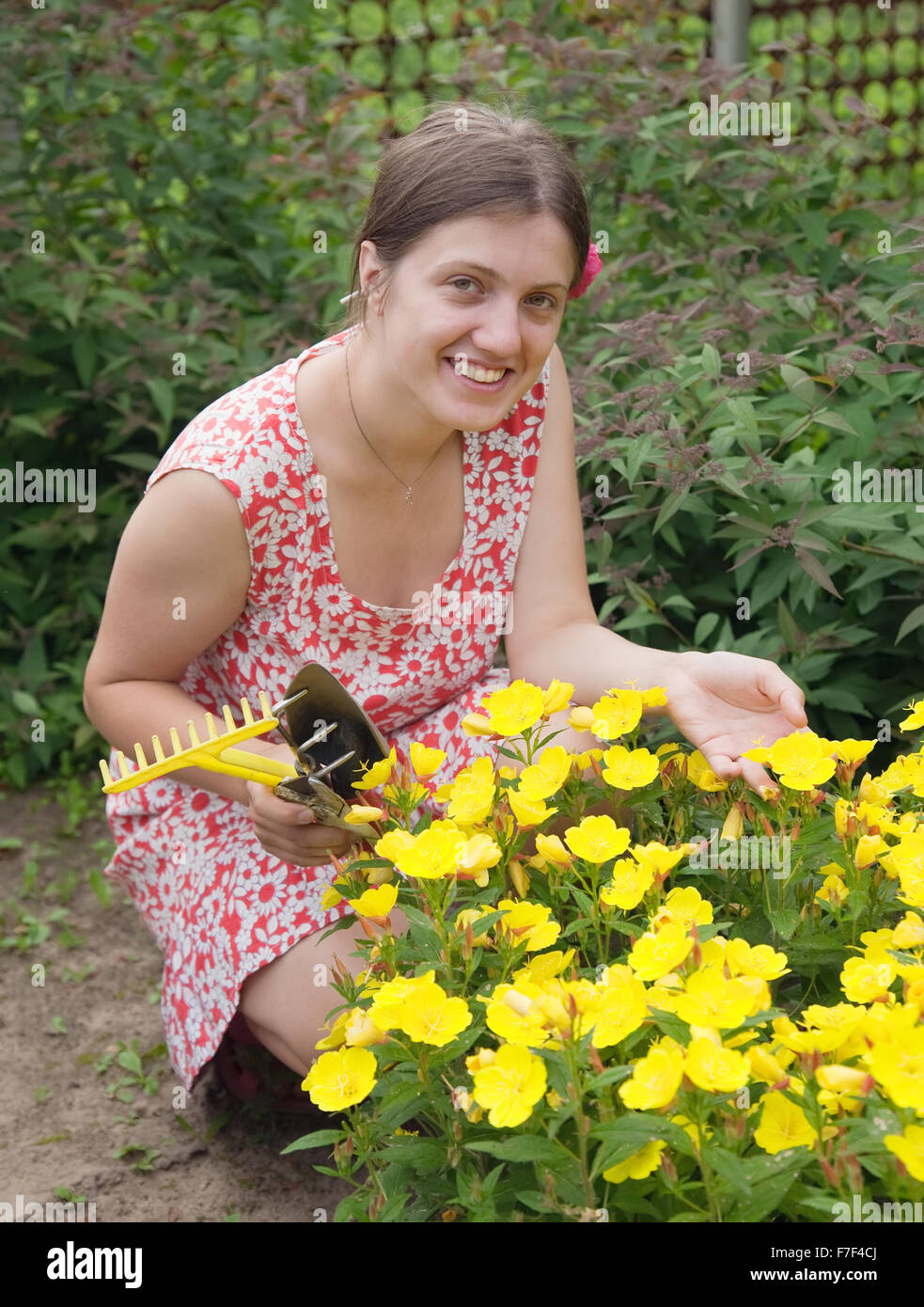 Beautiful young woman in the yard gardening Stock Photo - Alamy