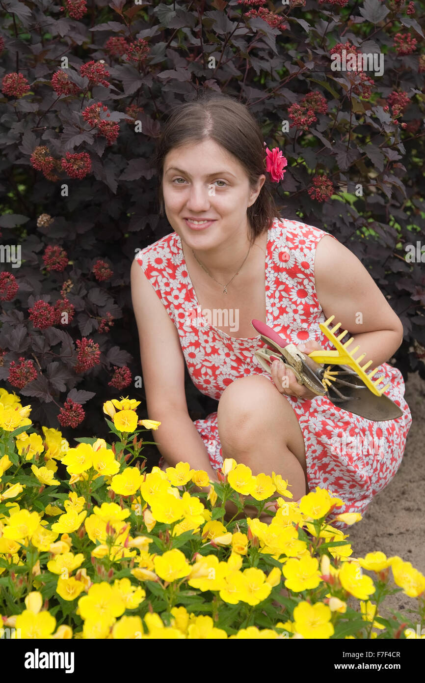 Beautiful young woman in the yard gardening Stock Photo - Alamy