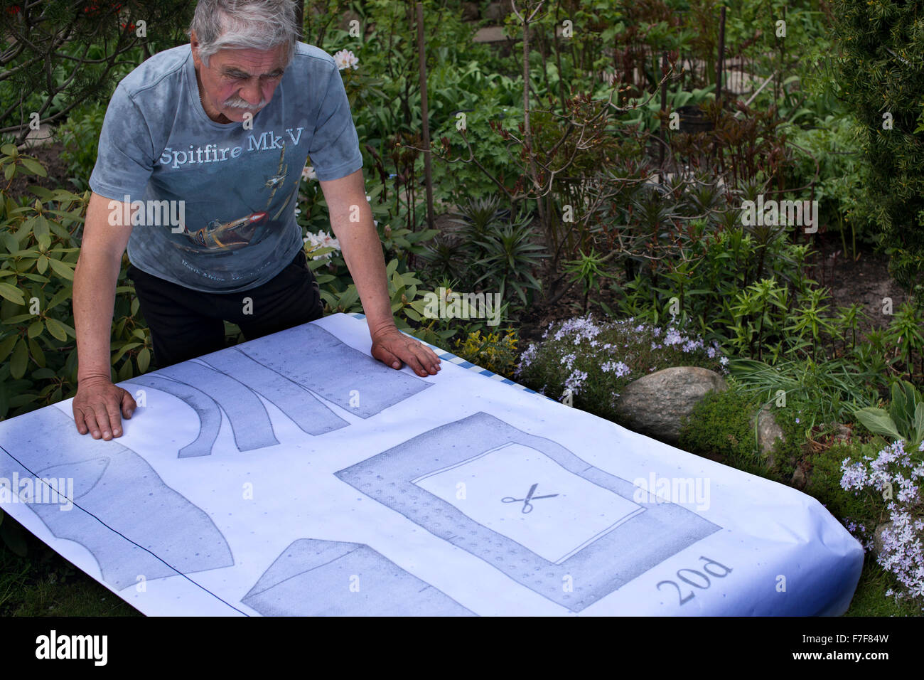 Old man reading blueprints Stock Photo - Alamy