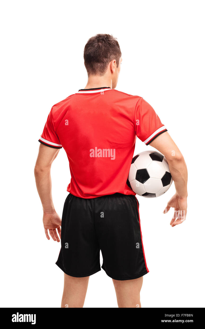 Rear view vertical shot of a young football player holding a ball ...