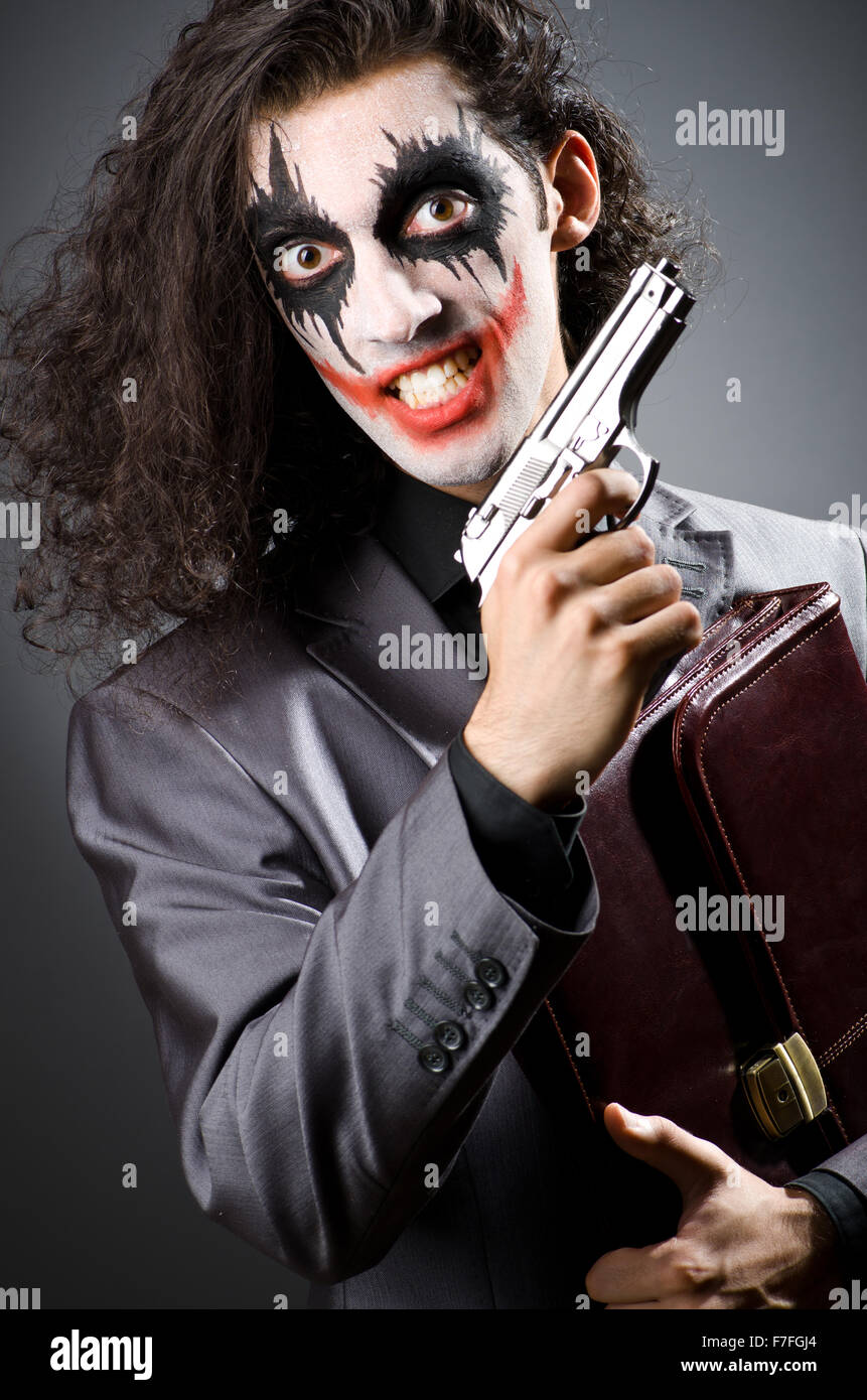 Joker with gun and briefcase Stock Photo - Alamy