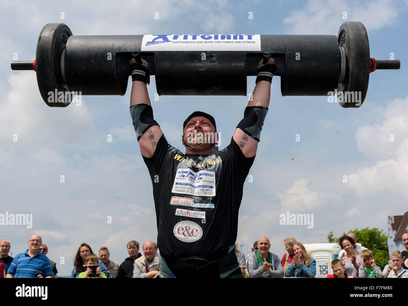 A strong man proves his strength at a public athletics sports event ...