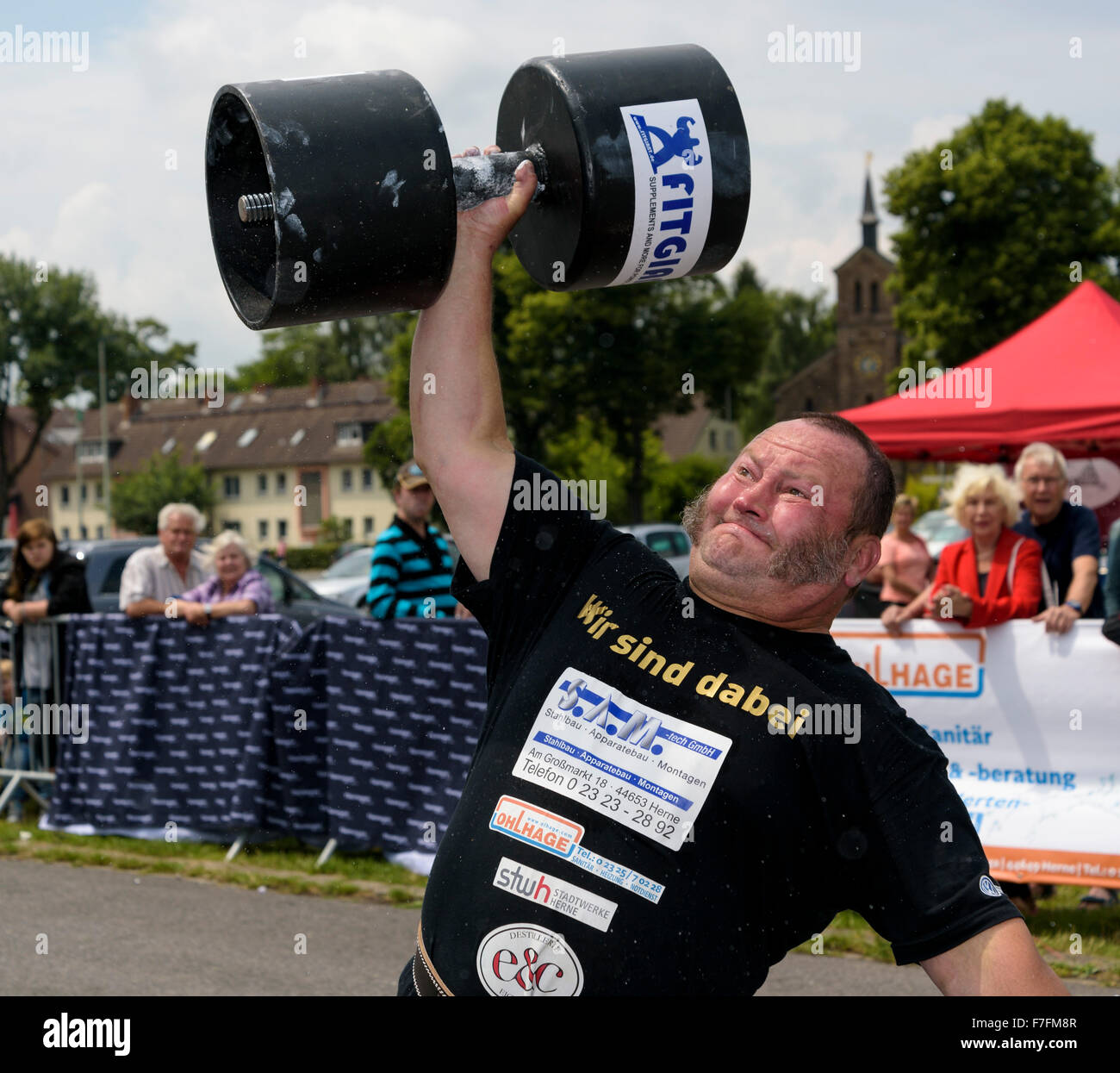 A strong man proves his strength at a public athletics sports event ...