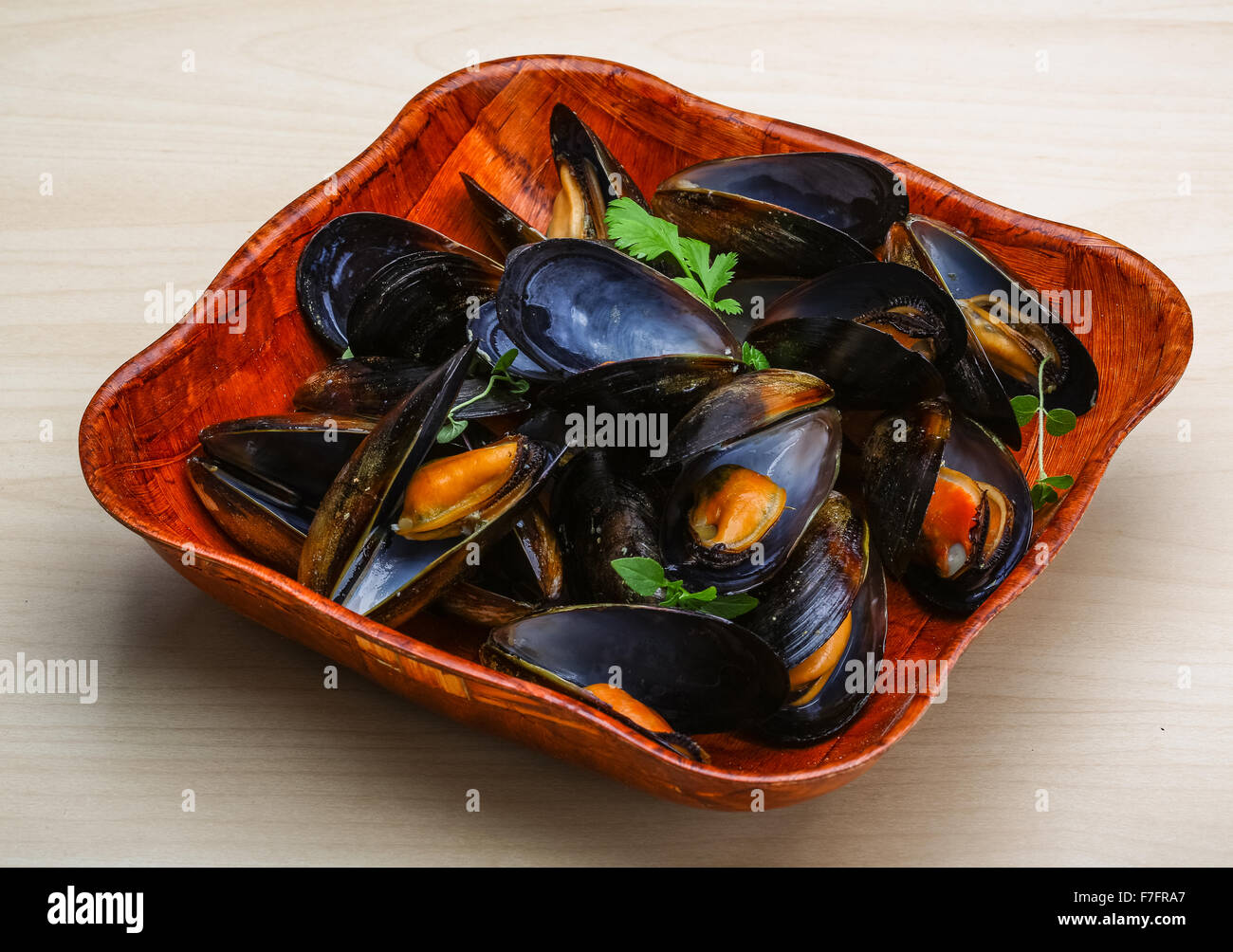 Fresh tasty Boiled mussels with herbs on wood background Stock Photo ...