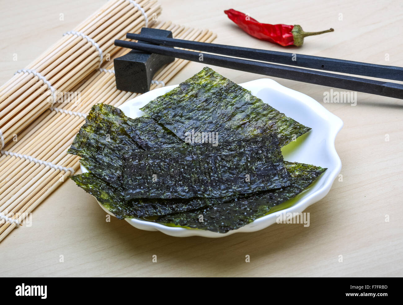 Nori sheets with sticks on the wood background Stock Photo - Alamy