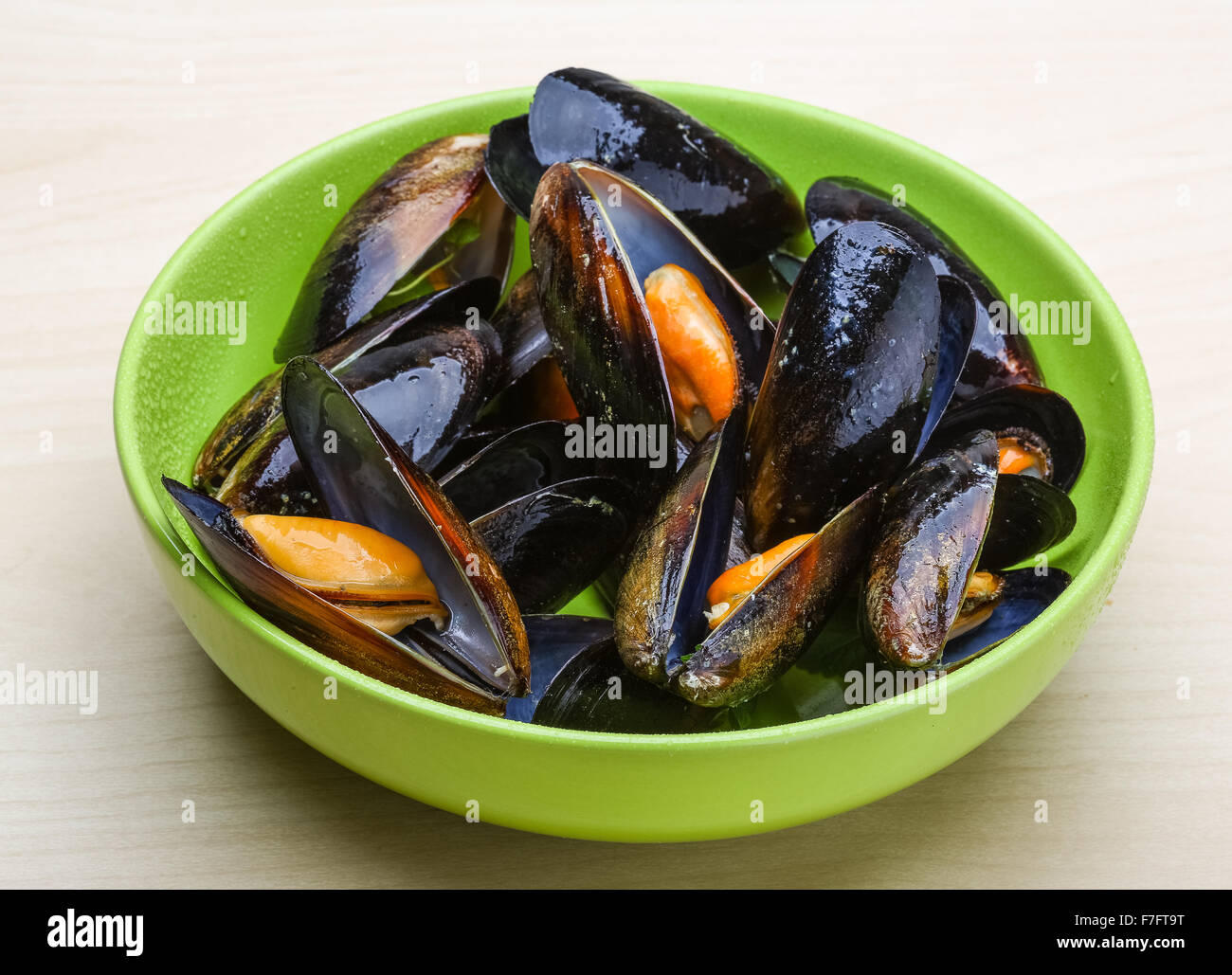 Fresh tasty Boiled mussels with herbs on wood background Stock Photo ...