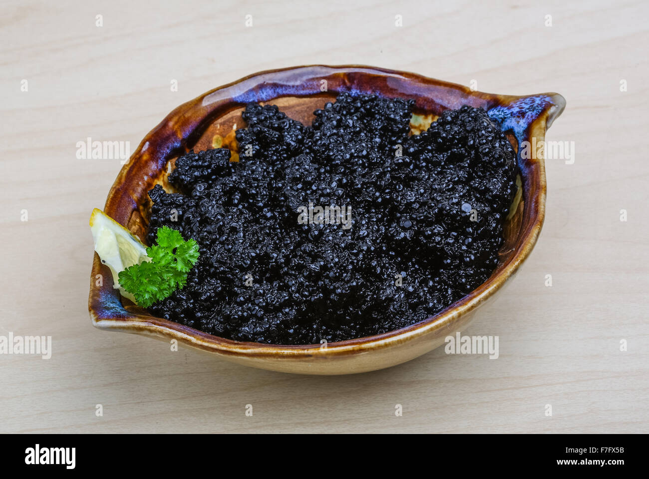Luxury Black caviar with green herb and lemon Stock Photo - Alamy