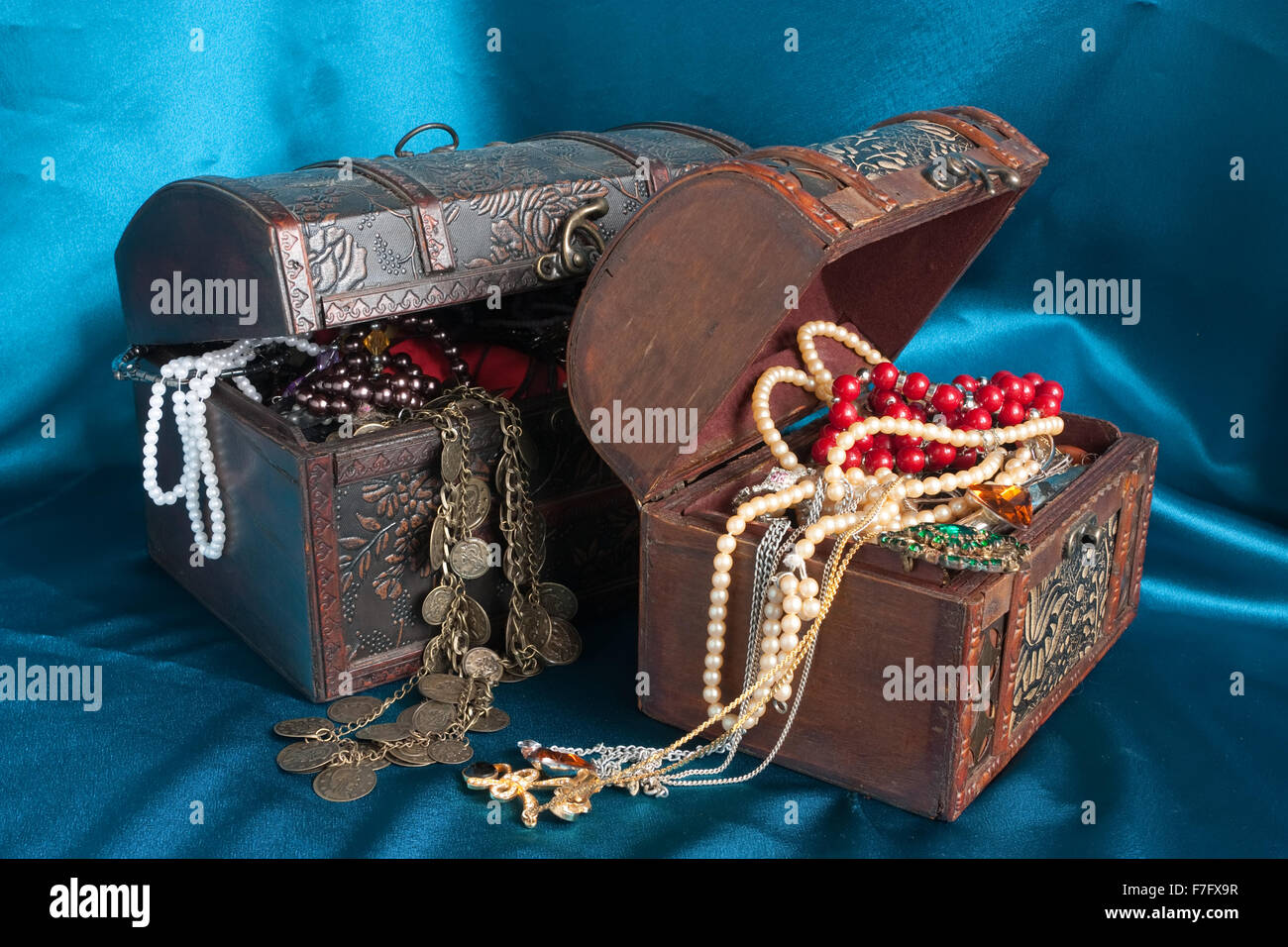 Two wooden treasure chests with valuables on blue textile Stock Photo ...