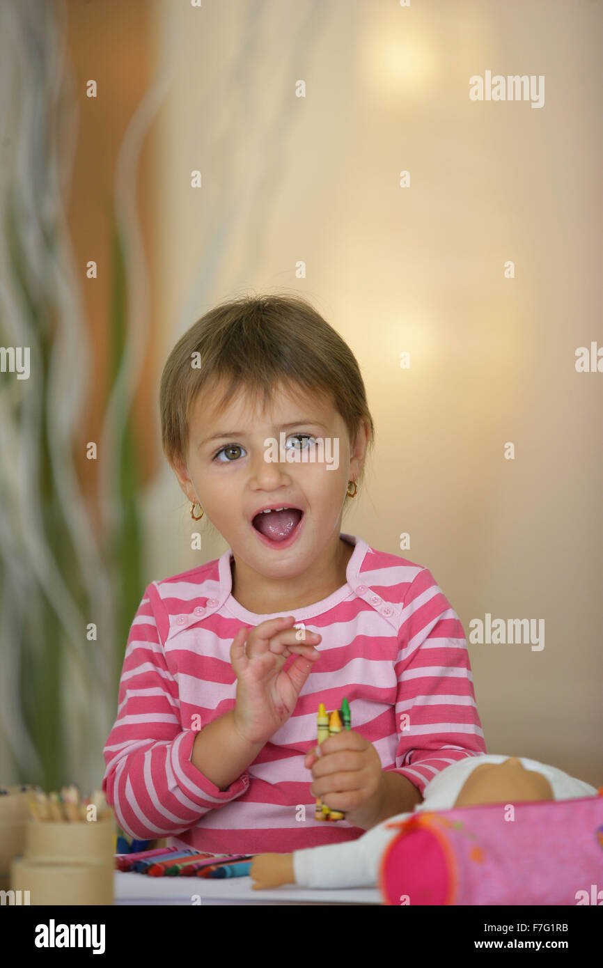Little girl drawing with colored crayons Stock Photo - Alamy