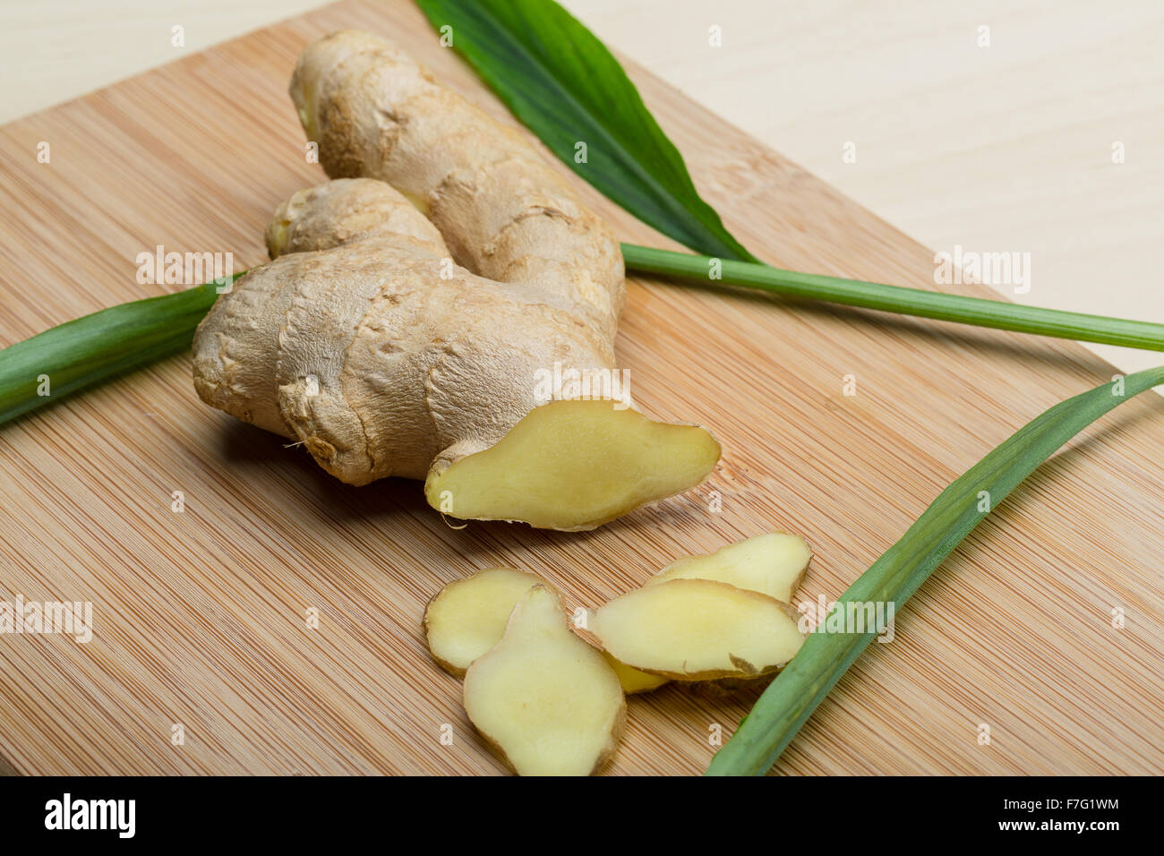 Ginger root on the wood background with leaves Stock Photo - Alamy
