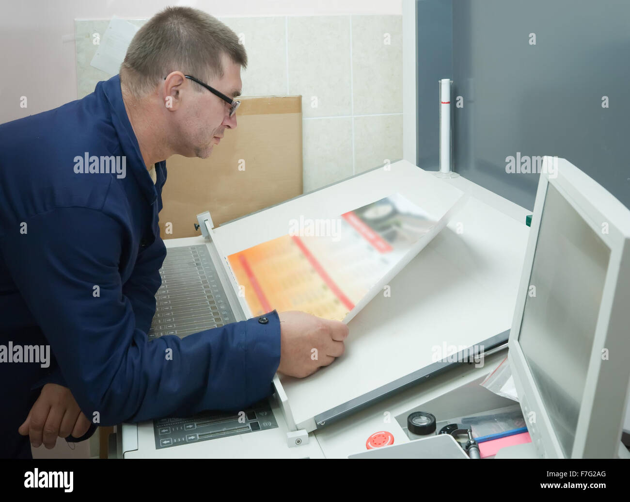 Printer checking a print run at table Stock Photo - Alamy