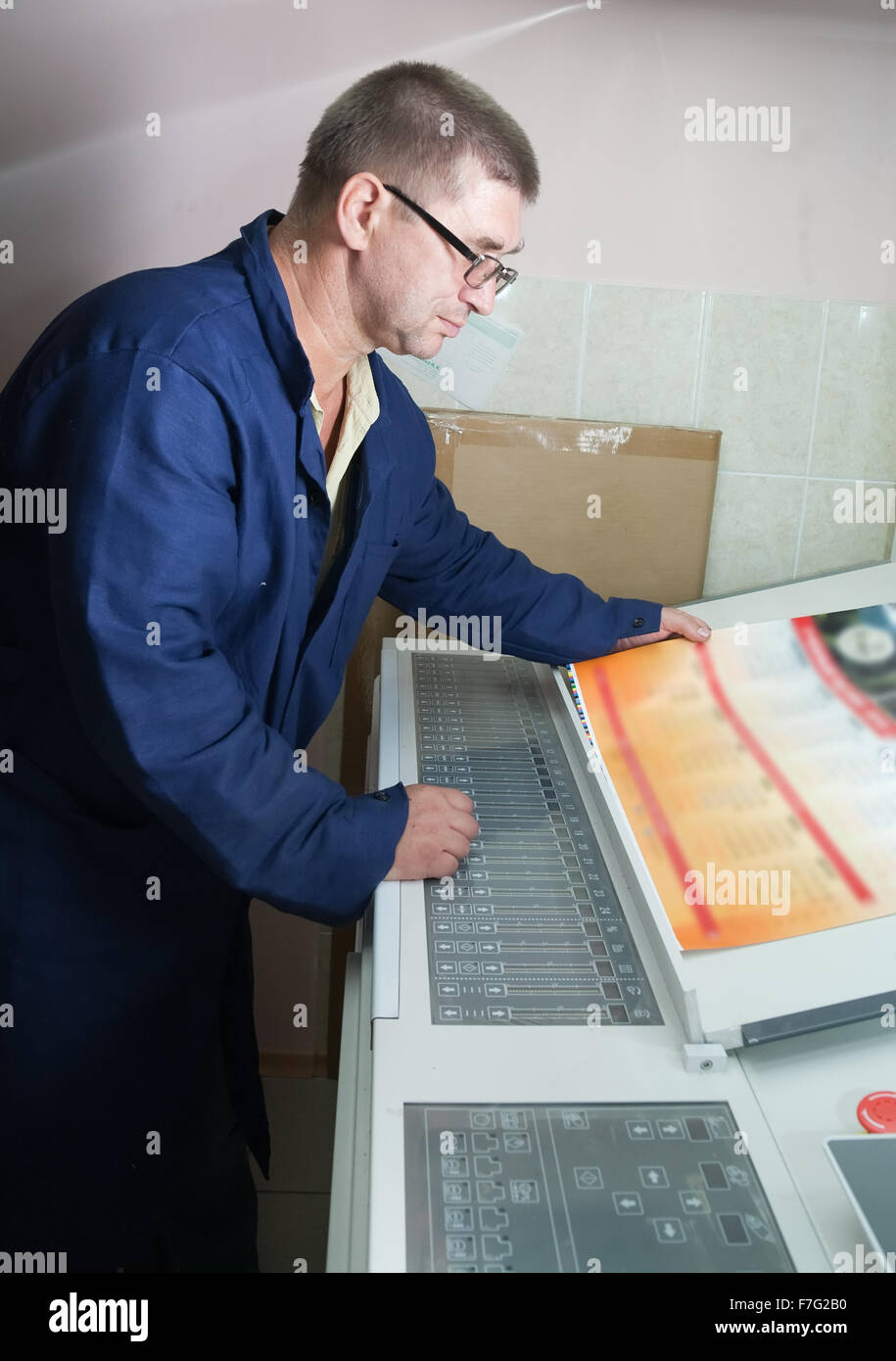 Printer checking a print run at table Stock Photo - Alamy